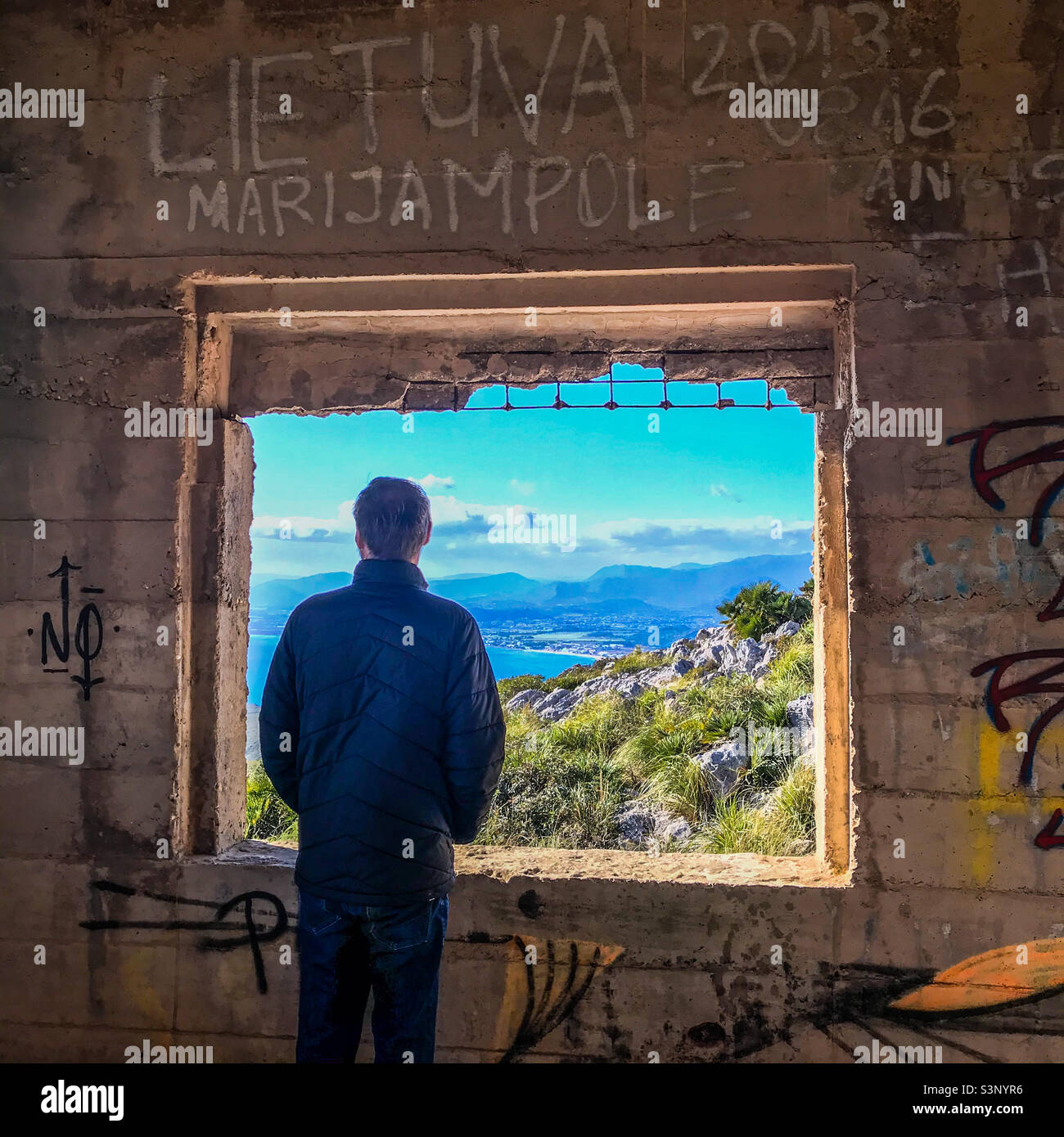 Man looking out window of abandoned building Stock Photo - Alamy