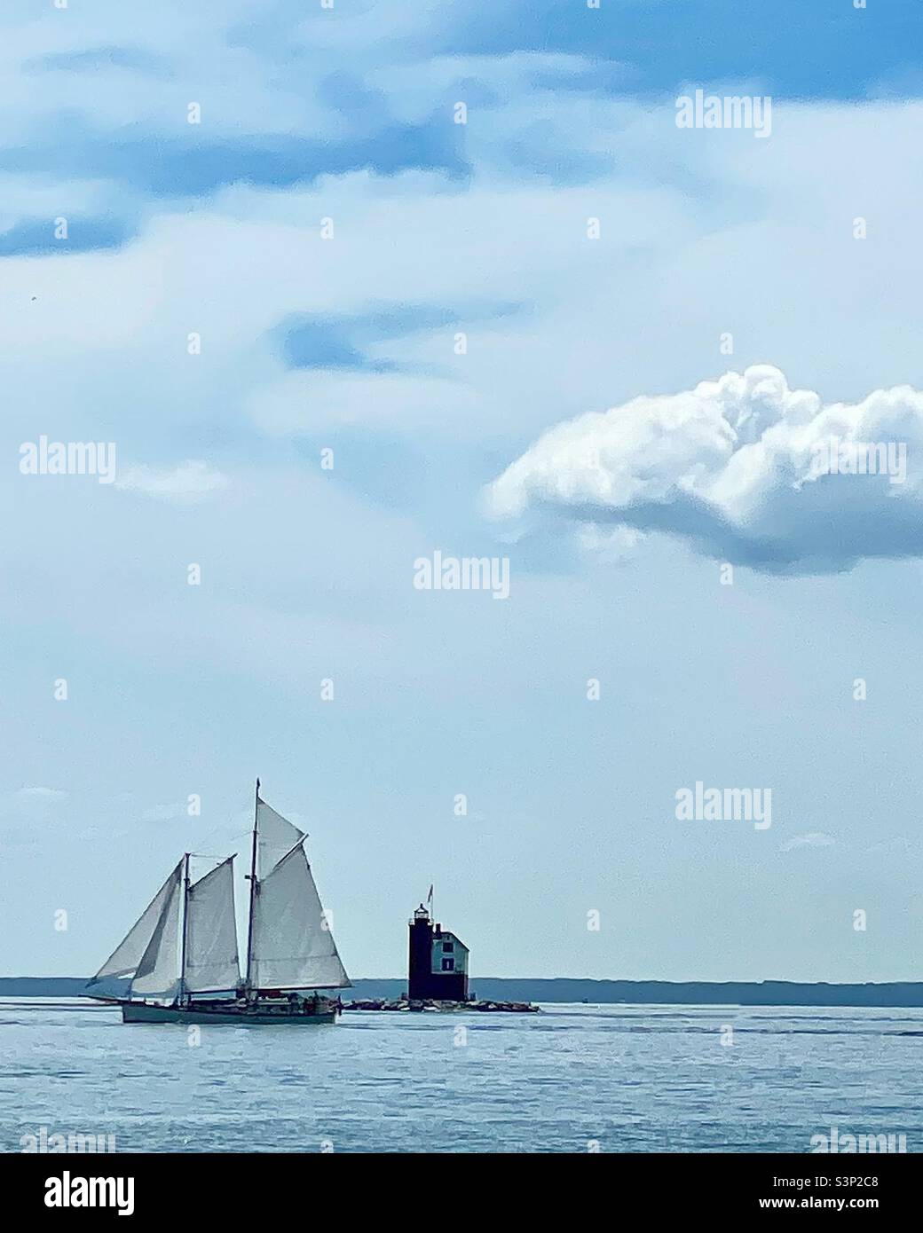 Schooner sailing by a lighthouse Stock Photo - Alamy