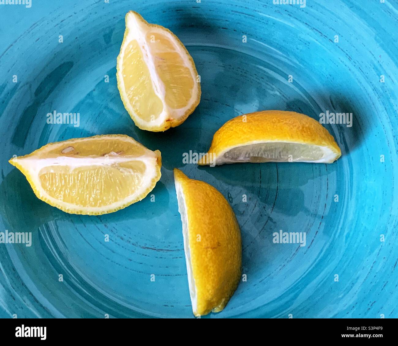Lemons slices on teal background Stock Photo - Alamy