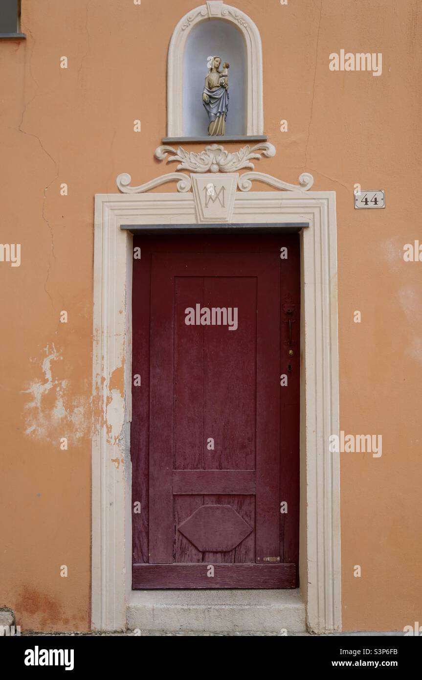 A red door with an inset statue of Mary holding Jesus in the old town ...