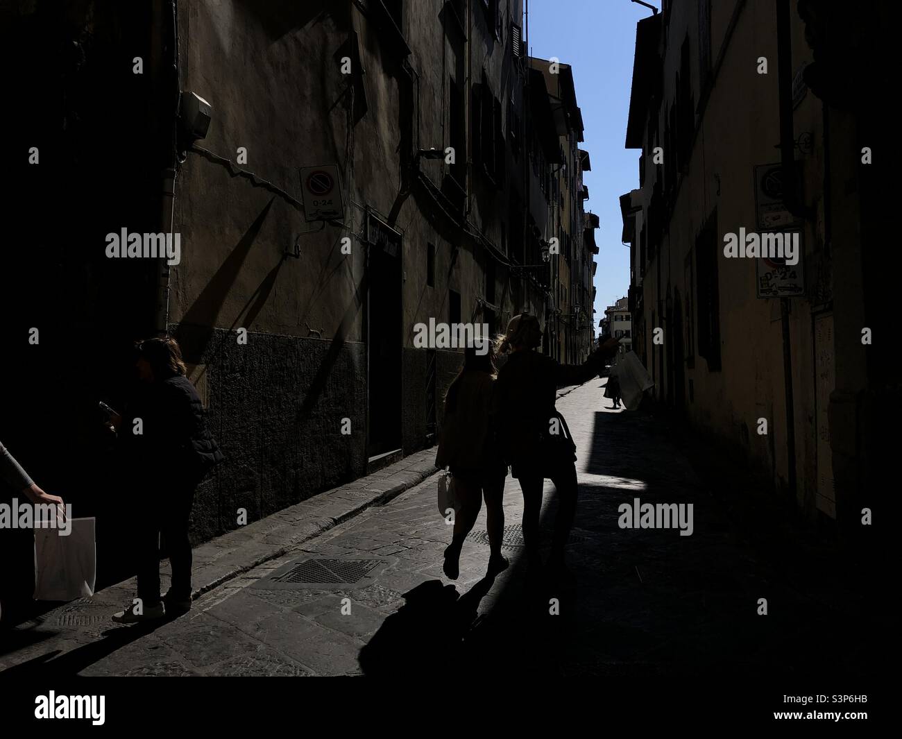 High contrast Silhouette of people on a narrow street in Florence Italy ...