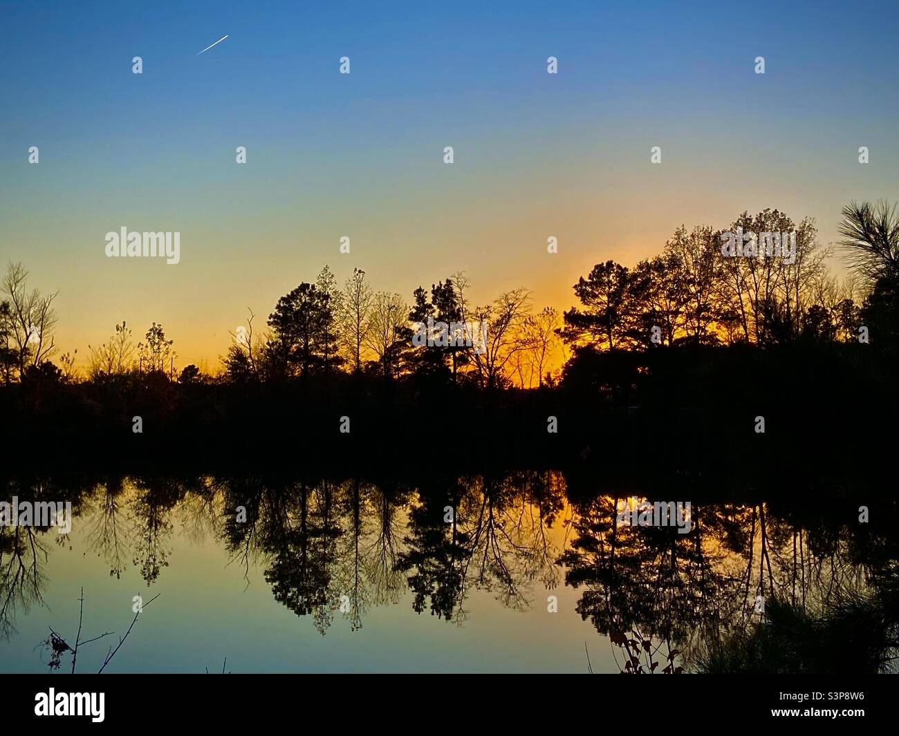 Orange and blue sky above pond Stock Photo - Alamy