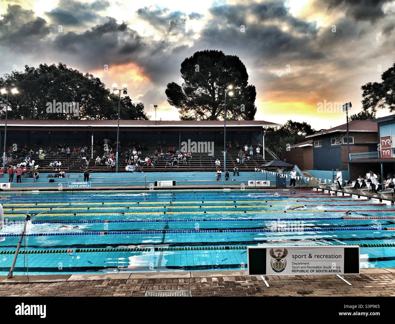 Dramatic sunset over a pool during a swimming meet/ gala in South ...