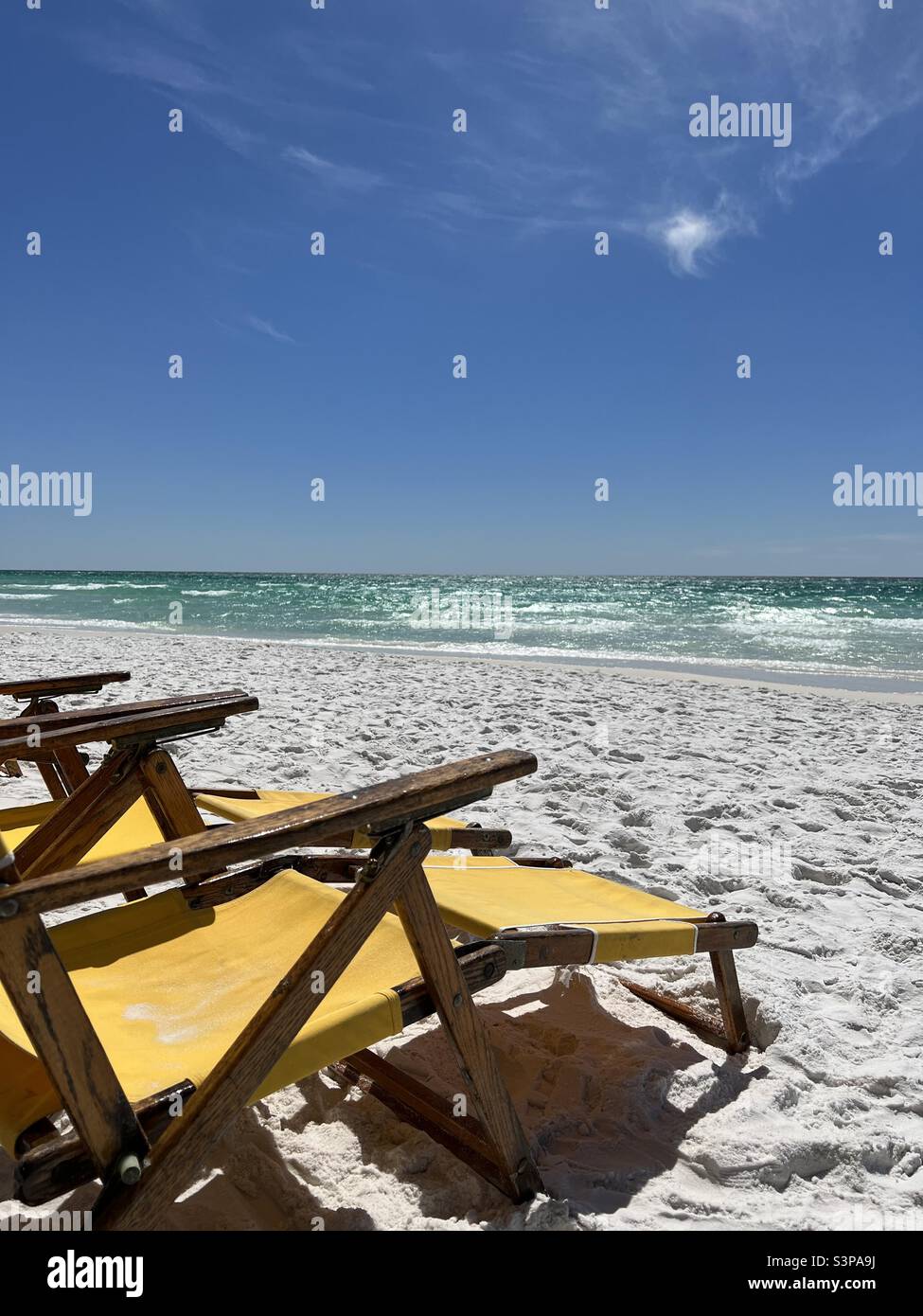 Yellow lounge chairs on white sand Florida beach with views of Gulf of ...