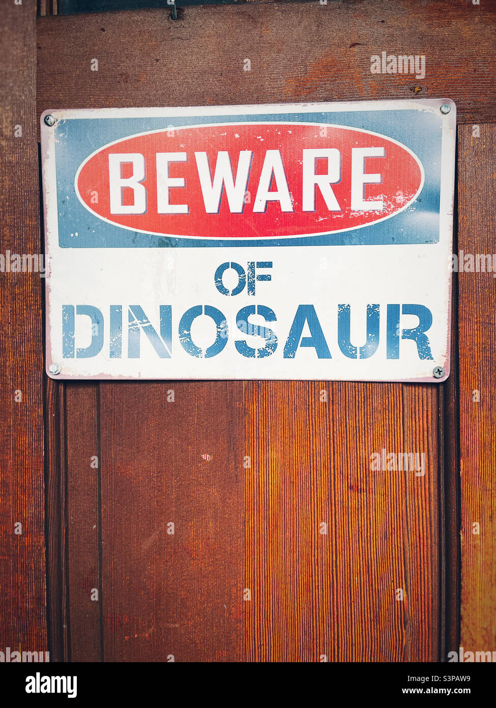 Beware of dinosaur sign on a door Stock Photo - Alamy