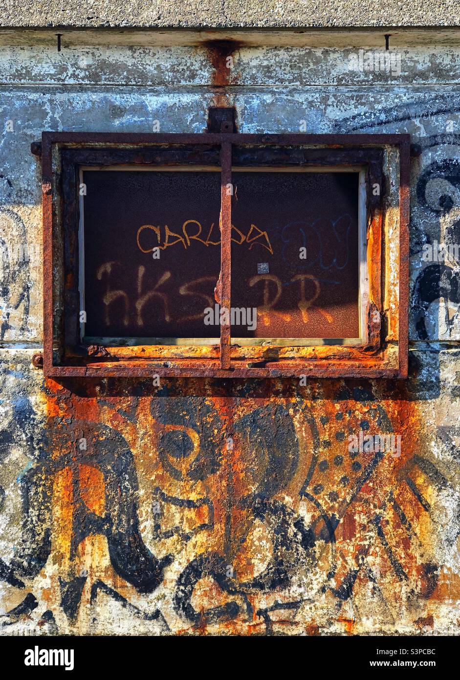 Rusting metal window frame on abandoned and graffiti covered out ...