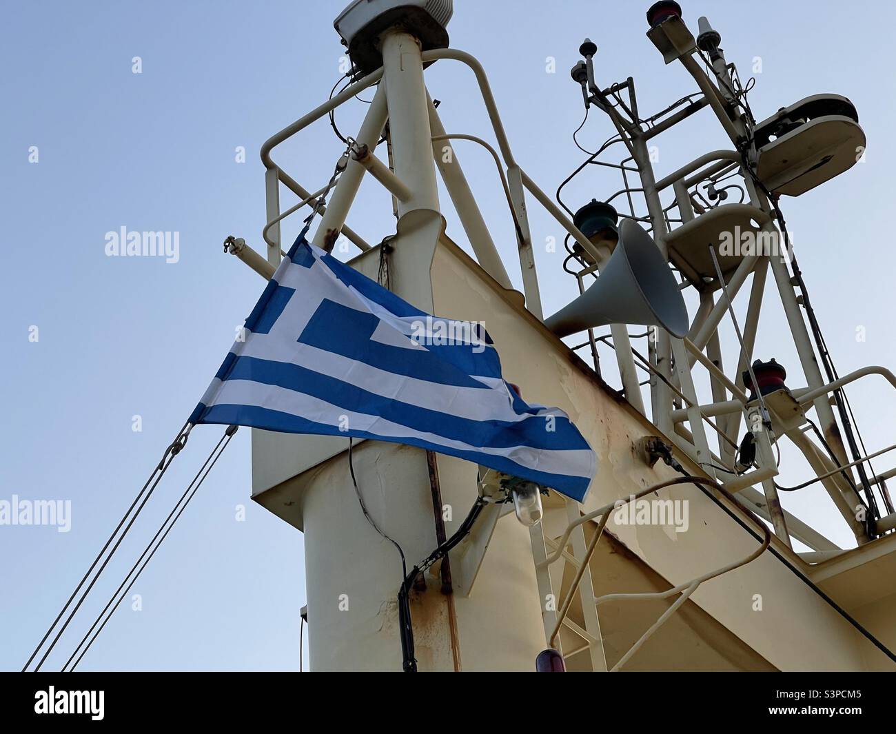 Flag of Greece on the navigational mast of cargo container vessel ...