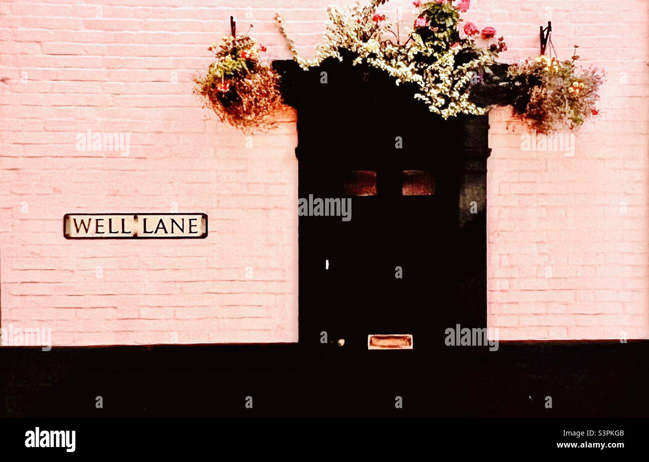 Pink brick building with flowers over door Well Lane Suffolk UK Stock ...
