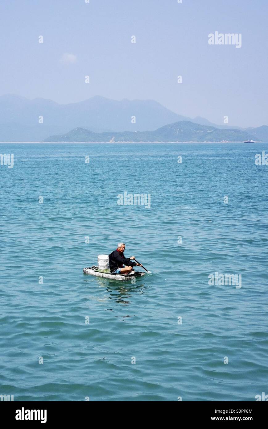 A Chinese man fishing from a tiny float near Lamma island in Hong Kong ...