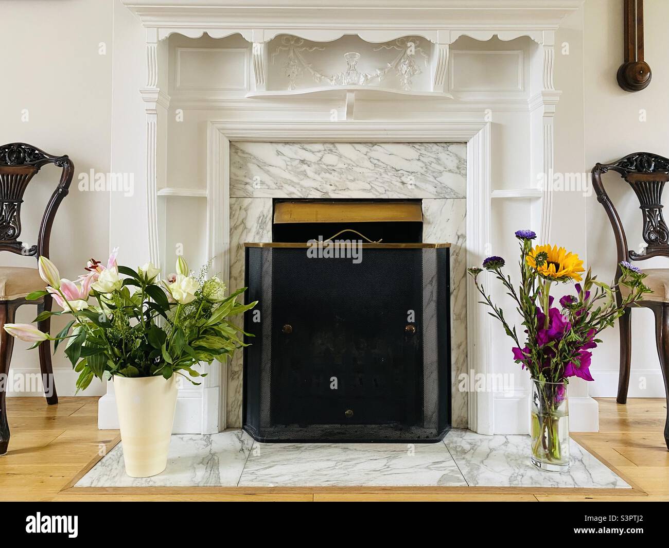 Pretty fireplace with two vases of flowers on the Hearthstone Stock ...