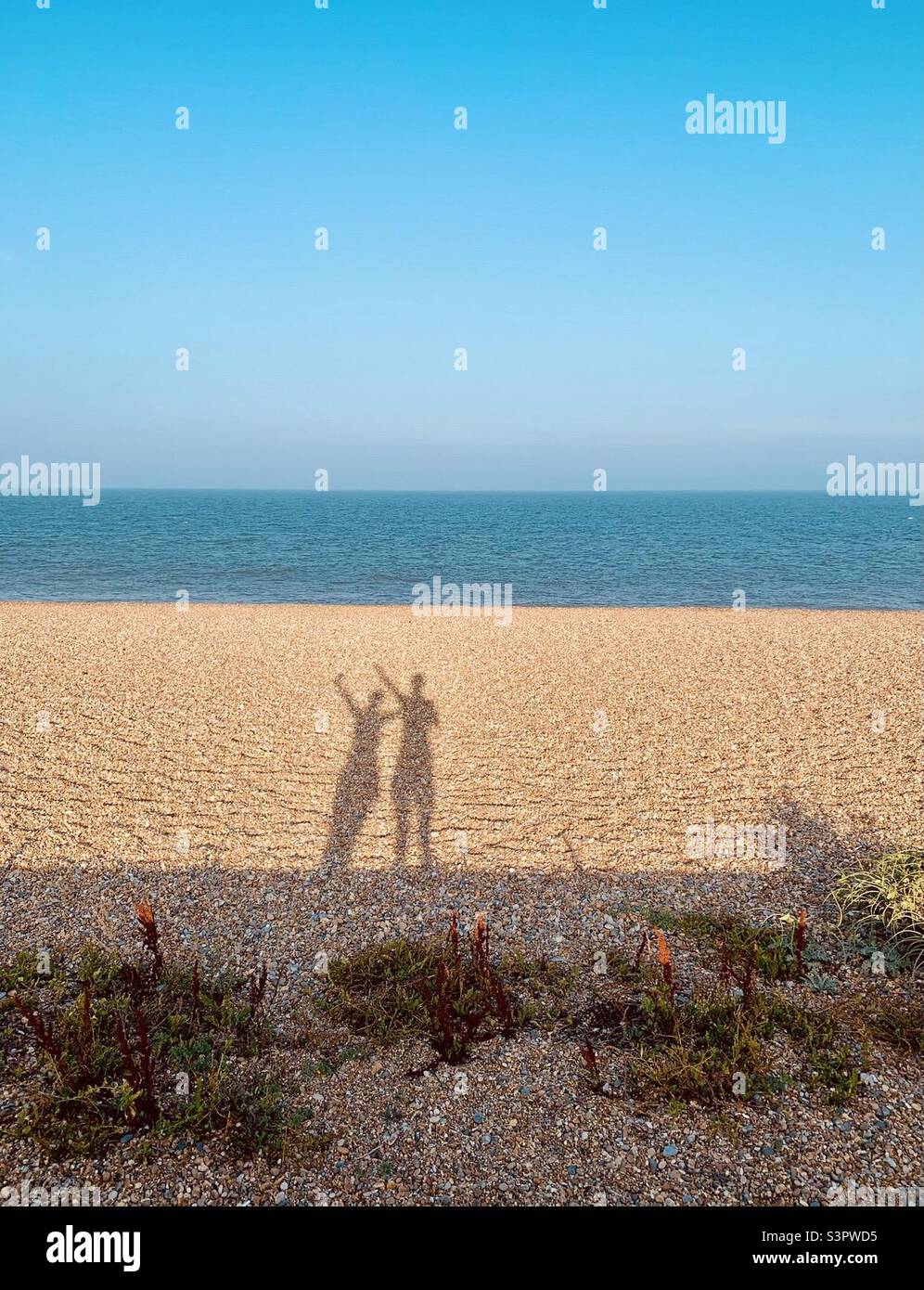Shadows on Stones - couple standing on sea wall with their shadows cast ...