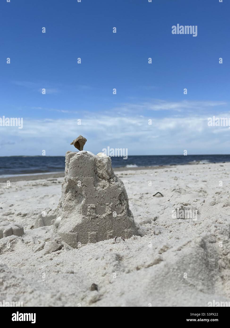 Sandcastle with seashell on the top Stock Photo - Alamy