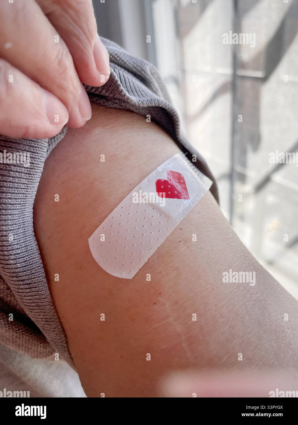 Flu shot injection Band-Aid being shown by a white man, 2022, USA Stock ...