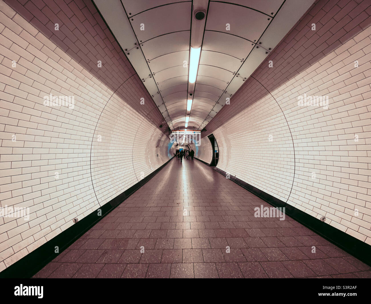 View along a long white tunnel at Tottenham Court Road London ...