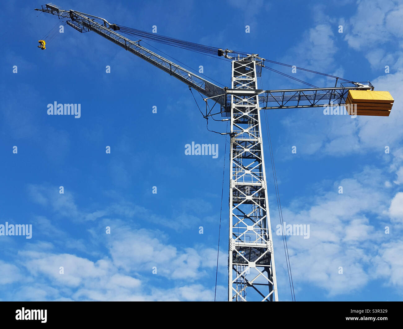 Tower crane for moving heavy loads on the background of the blue sky ...