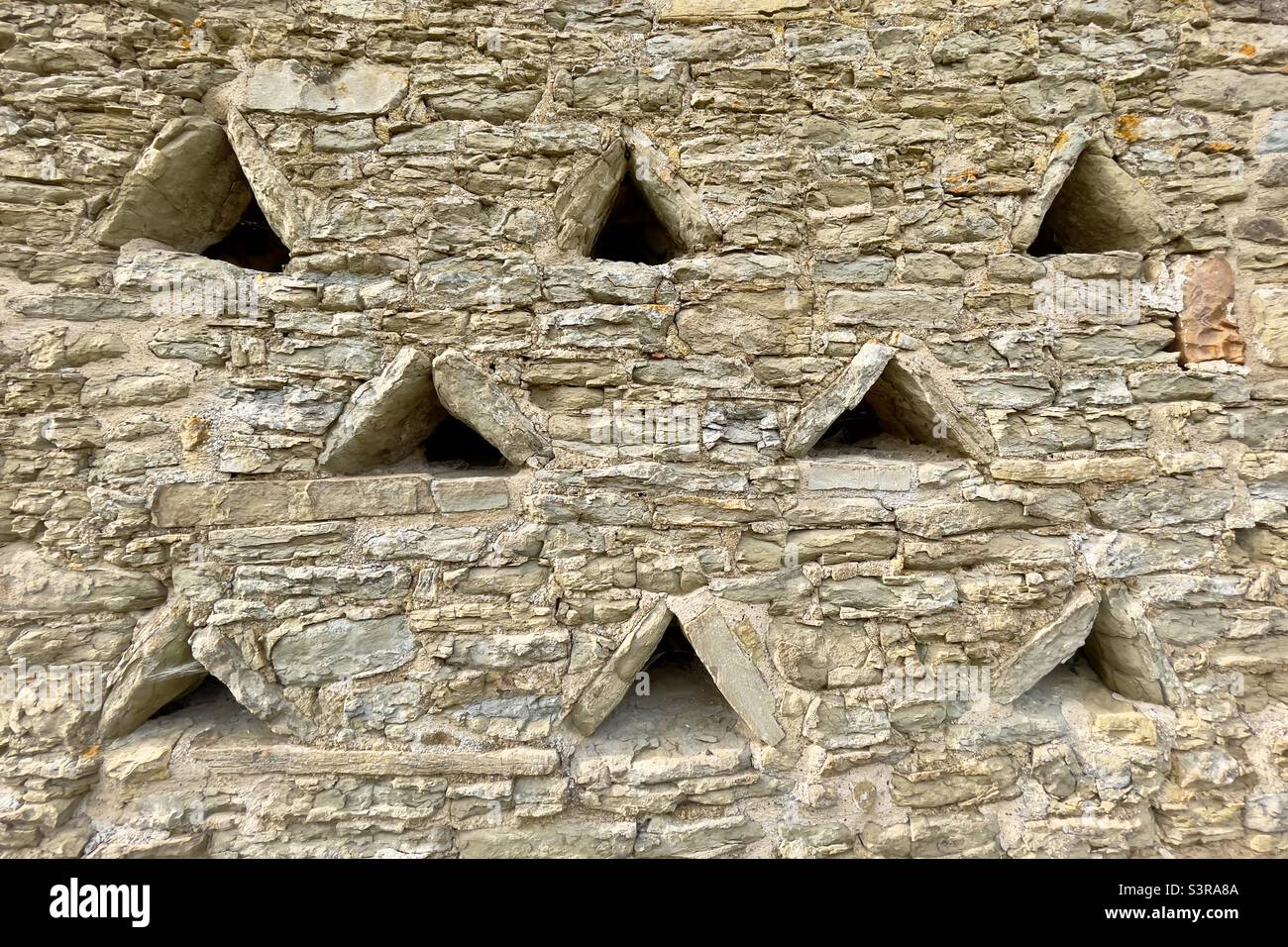 A group of triangular windows, or ventilation holes, in the wall of a ...