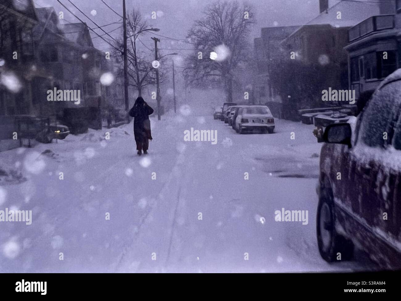 Pedestrian walking during Blizzard with Snow covered car during Boston ...