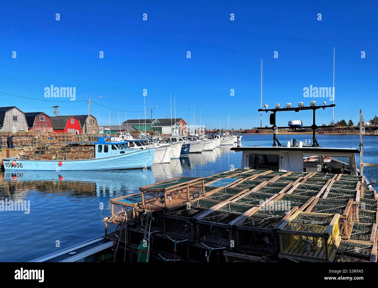 Fishing boats loaded with lobster traps and tied up at the wharf in ...
