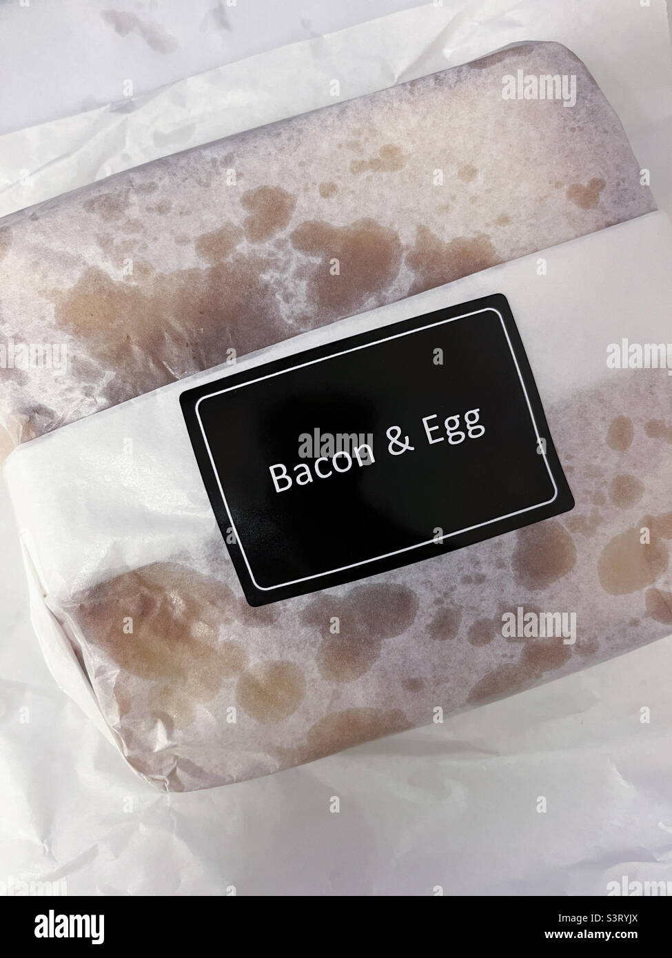 Paper wrapped bacon and egg sandwich Stock Photo - Alamy