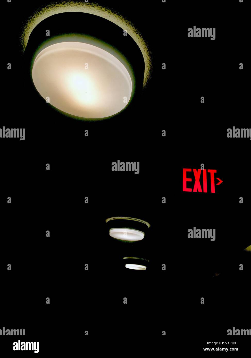 Ceiling lights and Exit sign in a long corridor Stock Photo - Alamy