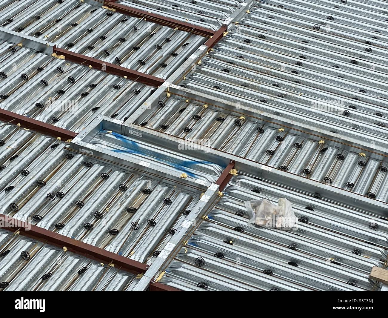 A grid of galvanised metalwork, the roof structure of a new building in ...