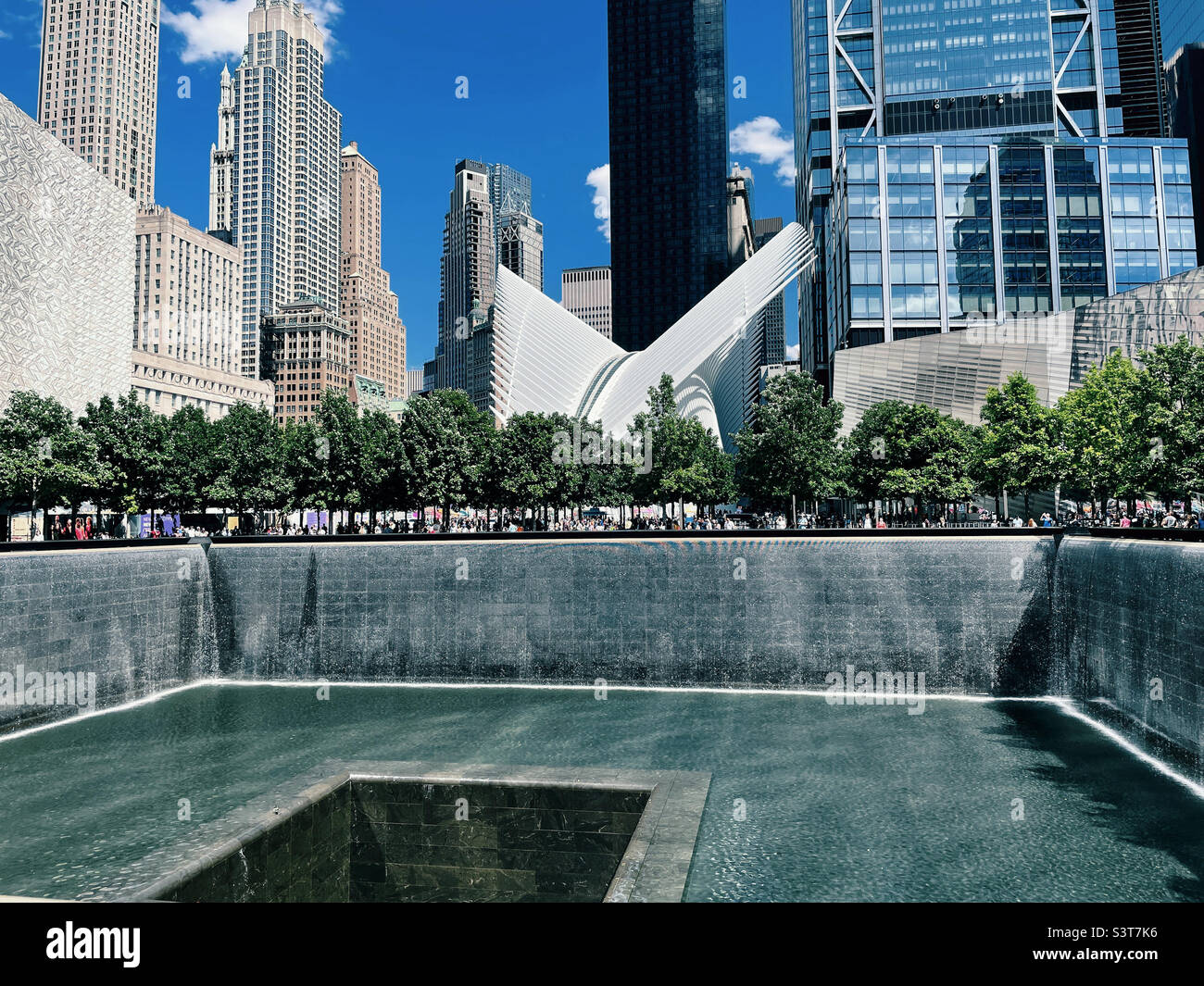 Tourists gather to view the waterfall foot print at the 911 Memorial in ...