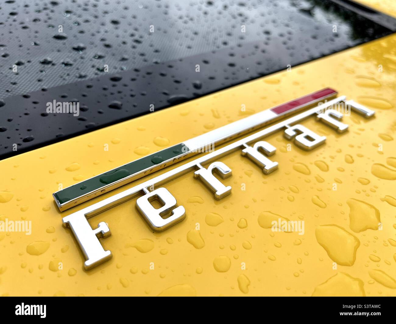 Ferrari original logo and sign on wet yellow finished car Stock Photo ...