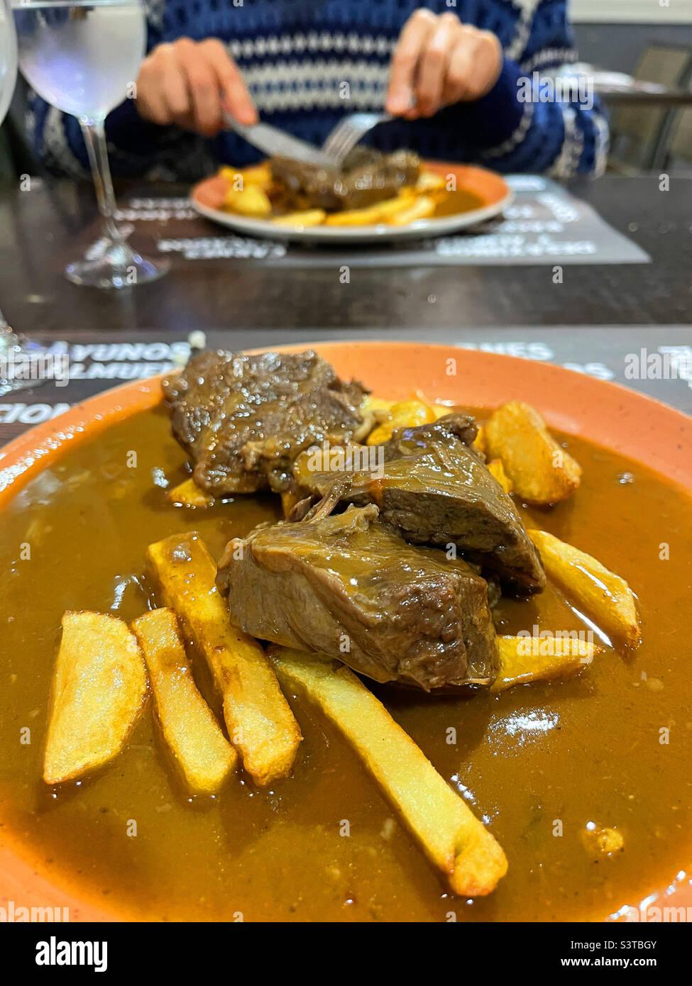 Eating meat stew with chips Stock Photo - Alamy