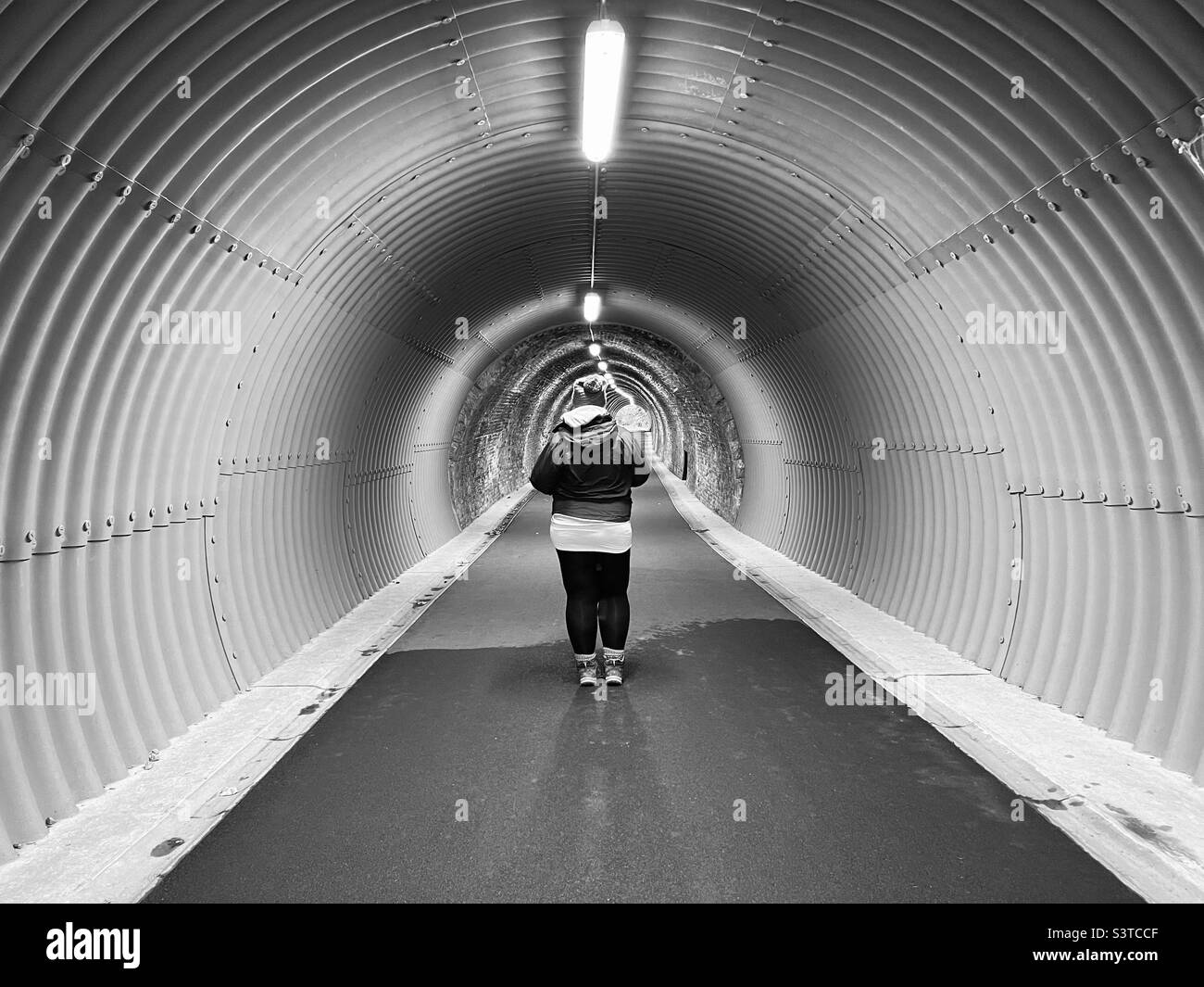 Woman walking into tunnel hi-res stock photography and images - Alamy