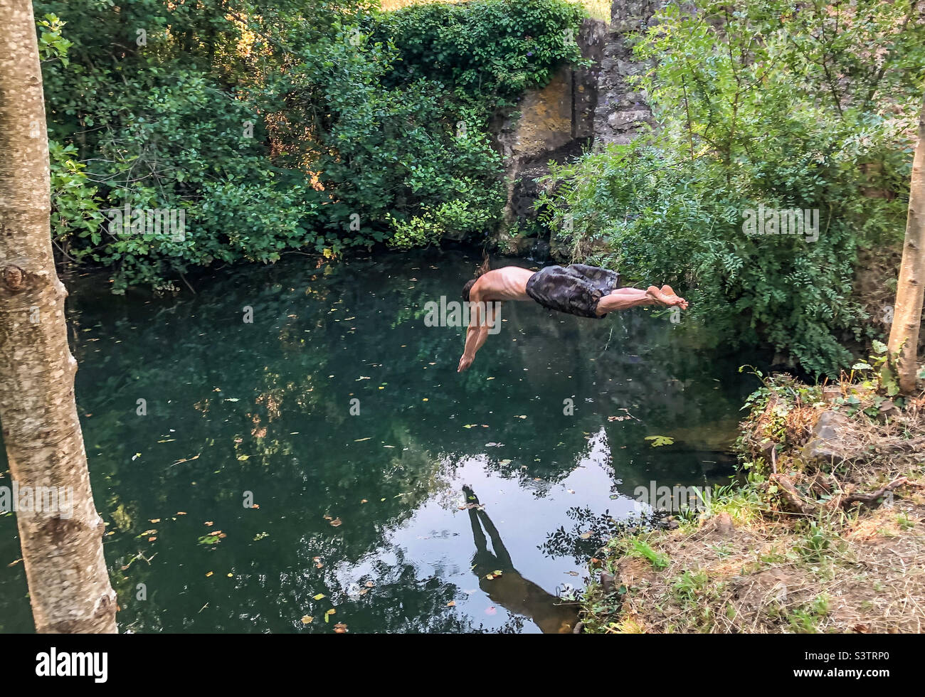 A man dives into a natural pool supplied from an underground water mine ...