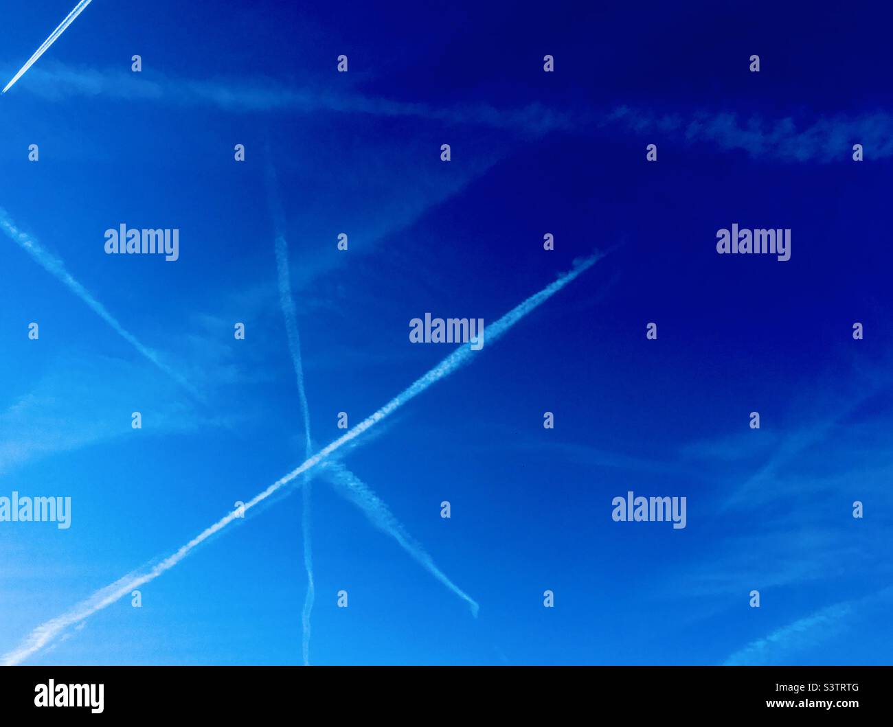 Blue sky with crossing condensation trails hi-res stock photography and ...