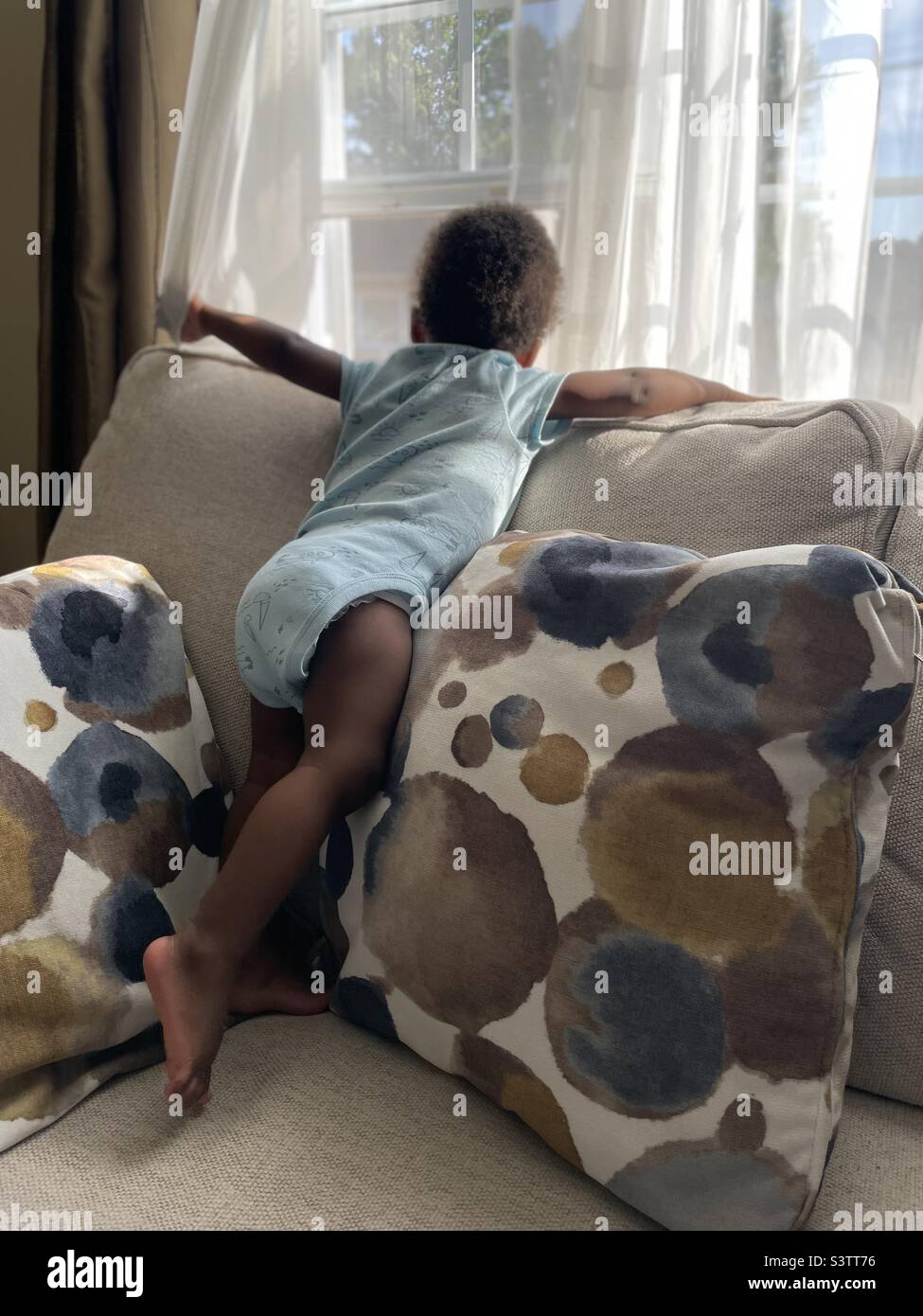 Baby looking out window Stock Photo - Alamy