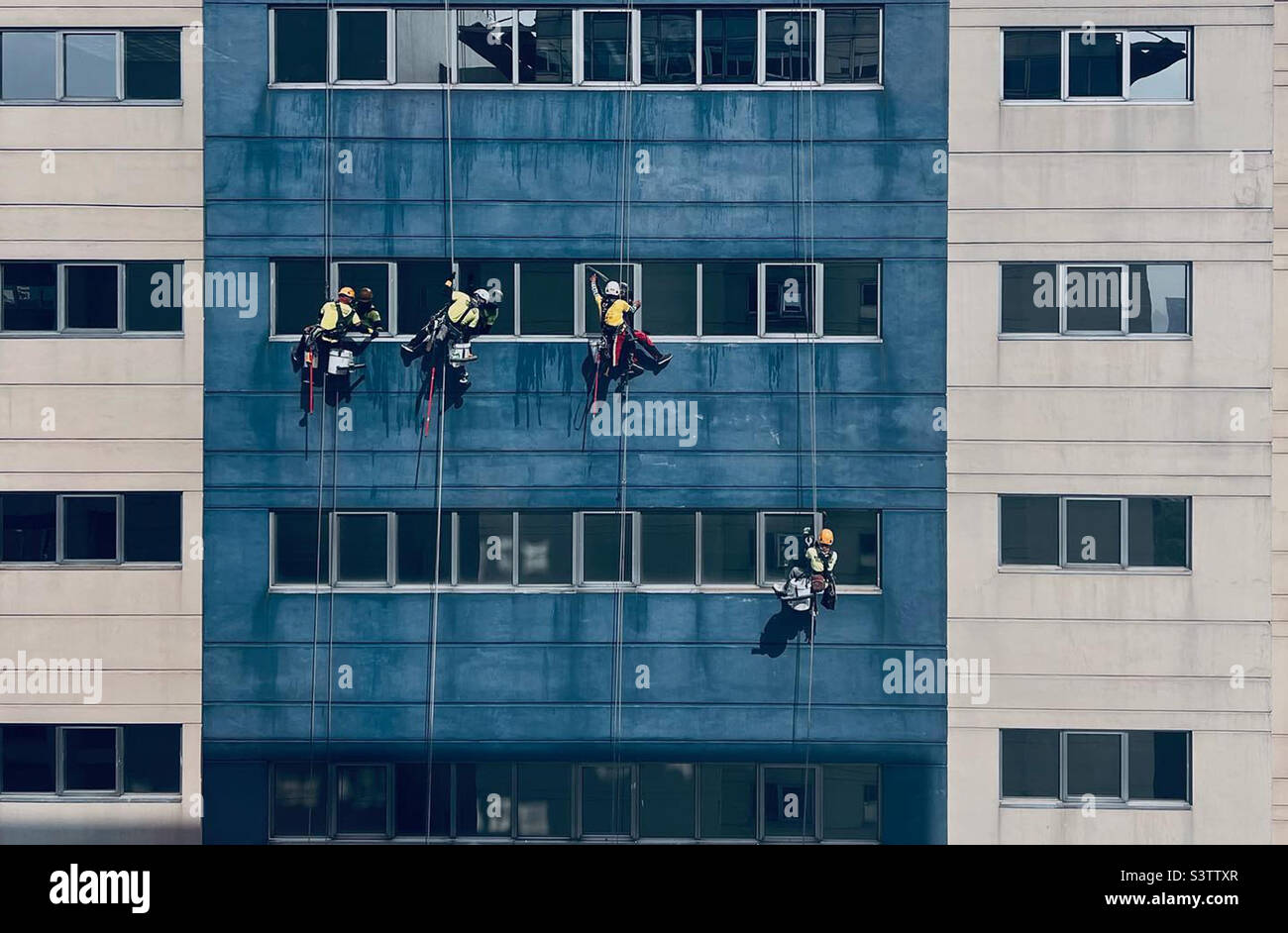 The real Spiderman working on a highrise buildings by painting and ...