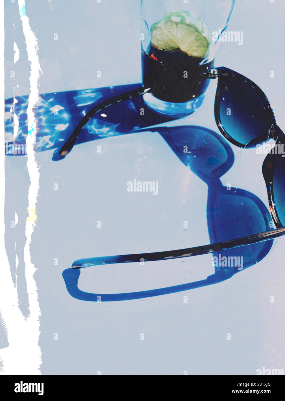 Summertime Refractions. Glass of fizzy cola with slice of slime and a ...