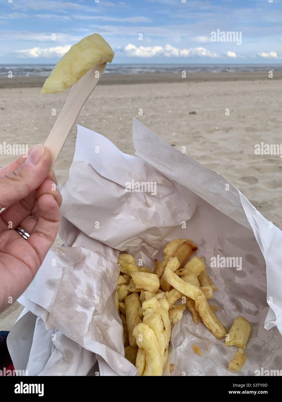 Chips being eaten on a beach Stock Photo - Alamy