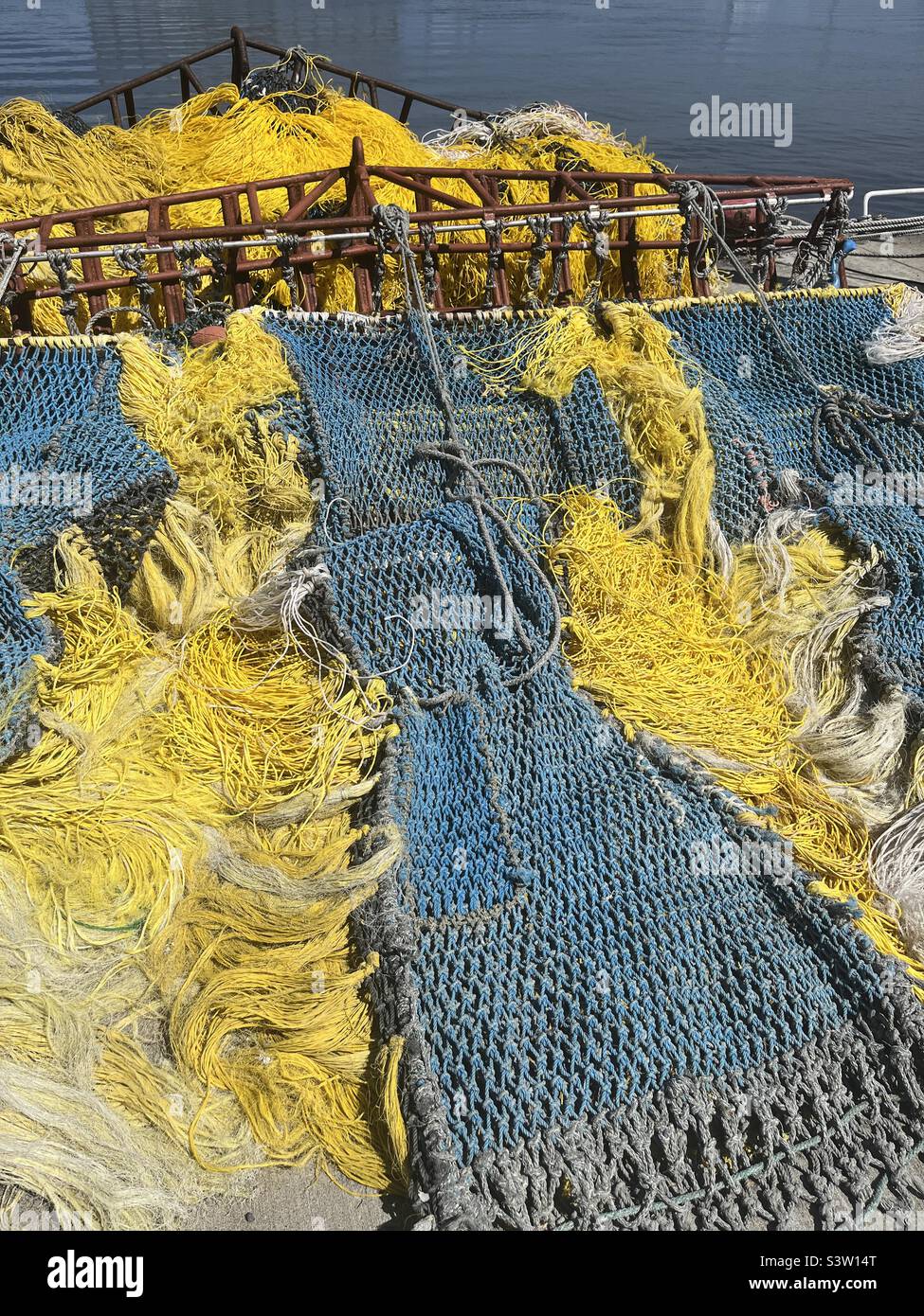 Yellow and blue commercial fishing nets Stock Photo - Alamy