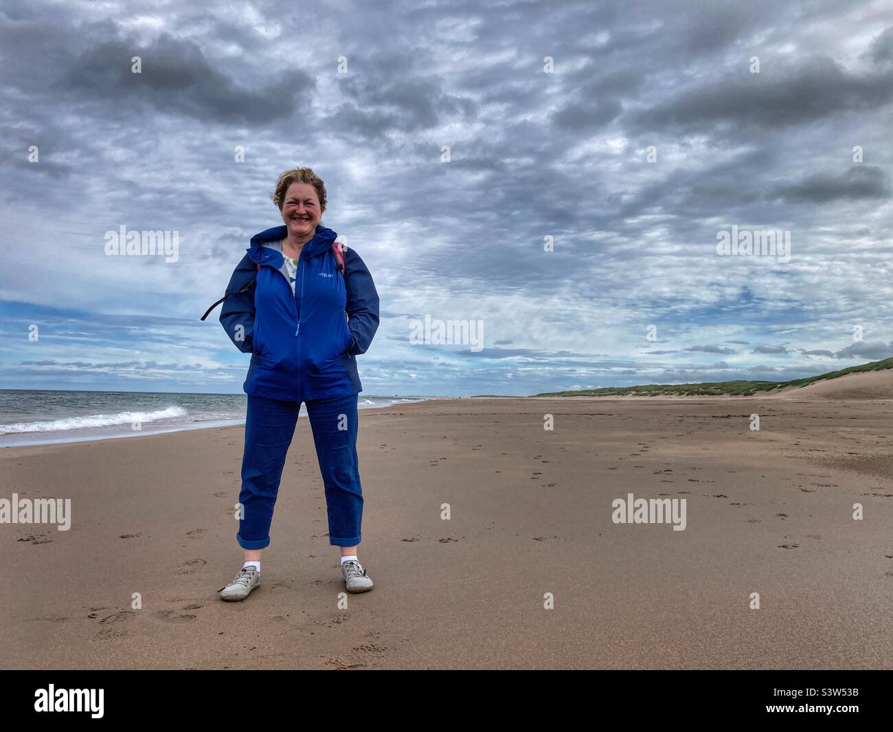 Woman on a deserted beach In Northumberland Stock Photo - Alamy