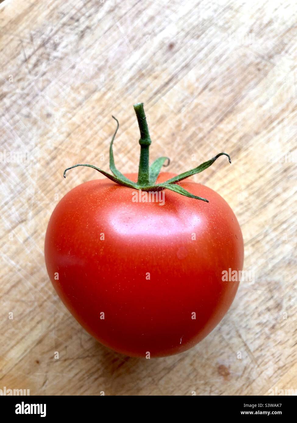 Red ripe tomato on wooden desk Stock Photo - Alamy