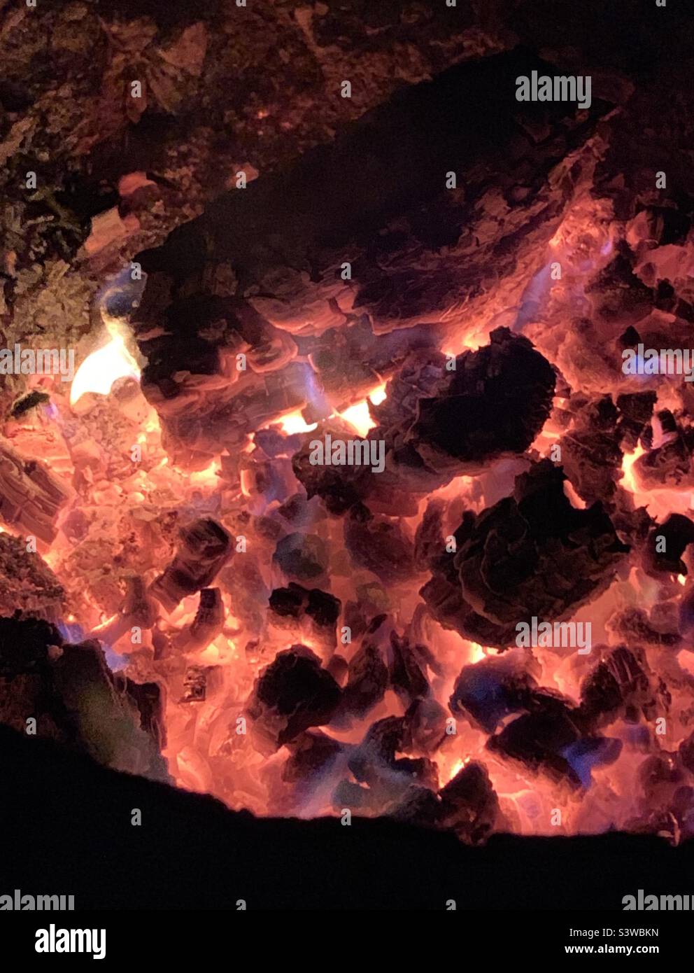 Embers with orange and blue flames Stock Photo - Alamy