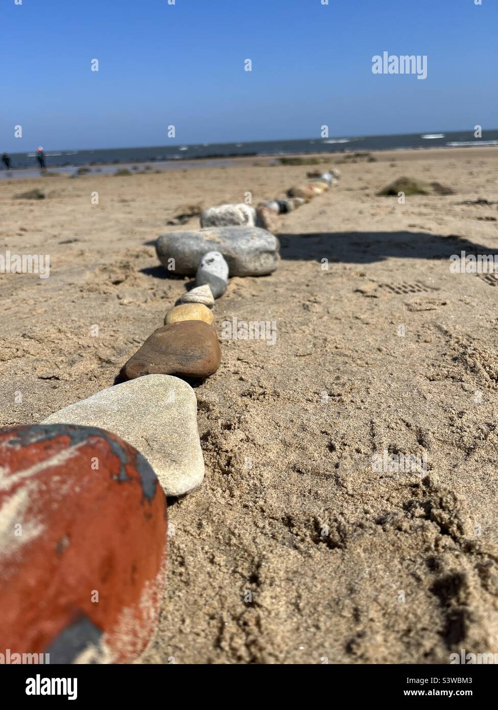 A line of stones down to the sea Stock Photo - Alamy