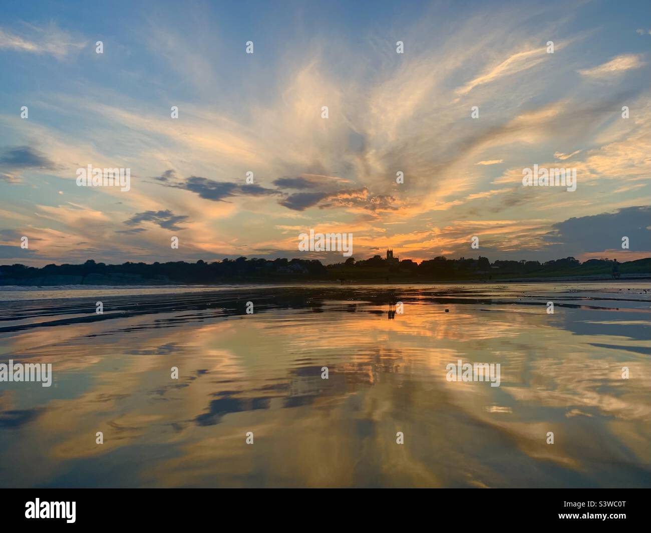 Dramatic sunset reflection on the beach Stock Photo - Alamy