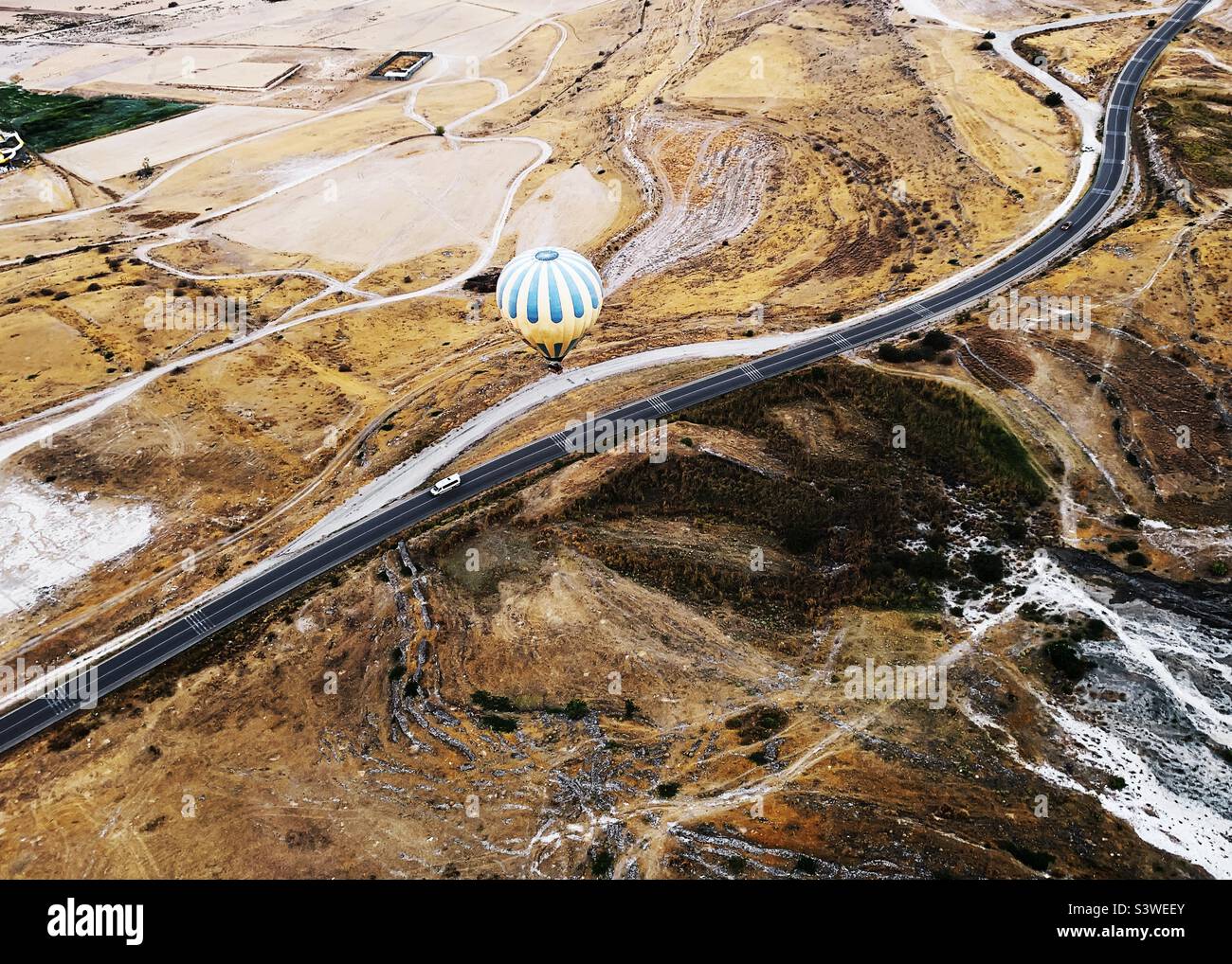 Hot air balloon flying over the road Stock Photo - Alamy