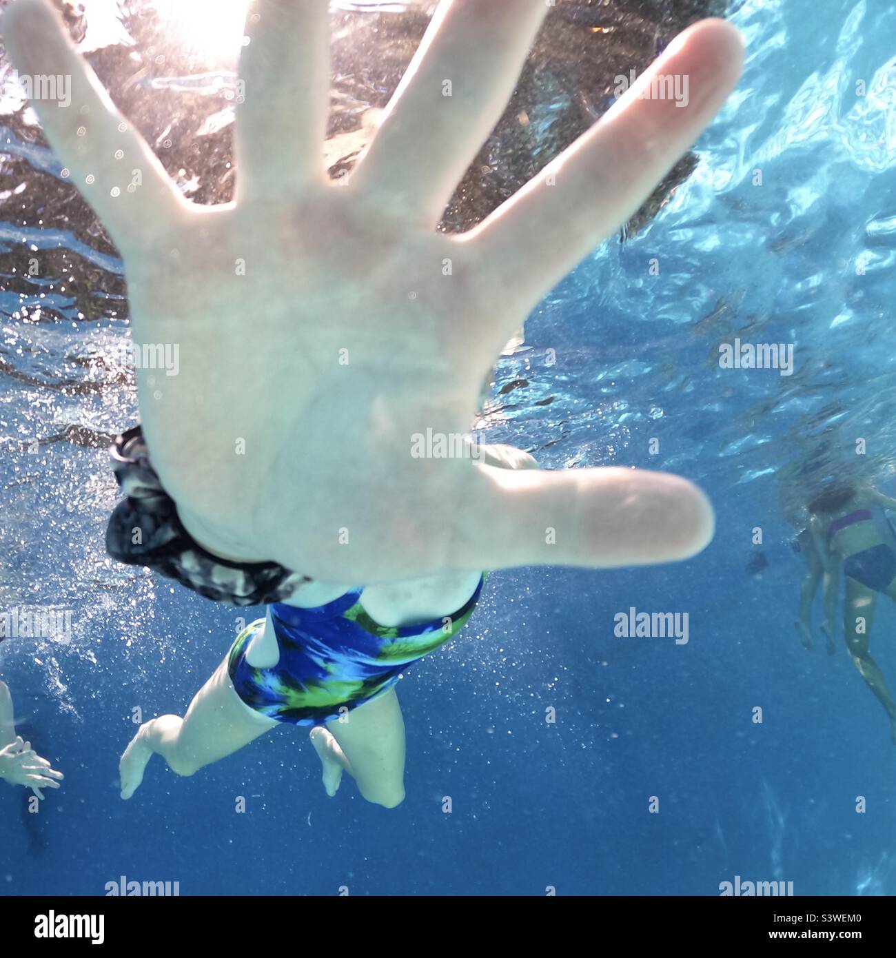 Girl holds her hand out to block someone from taking a picture of her ...