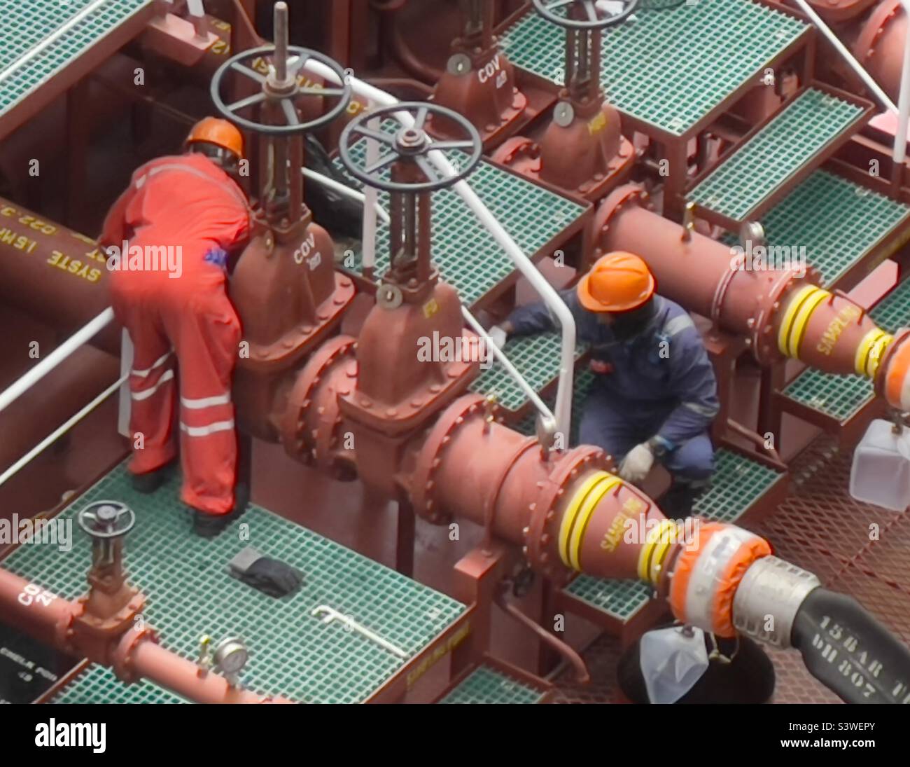 Operatives working on a bunkering vessel in Gibraltar harbour servicing ...