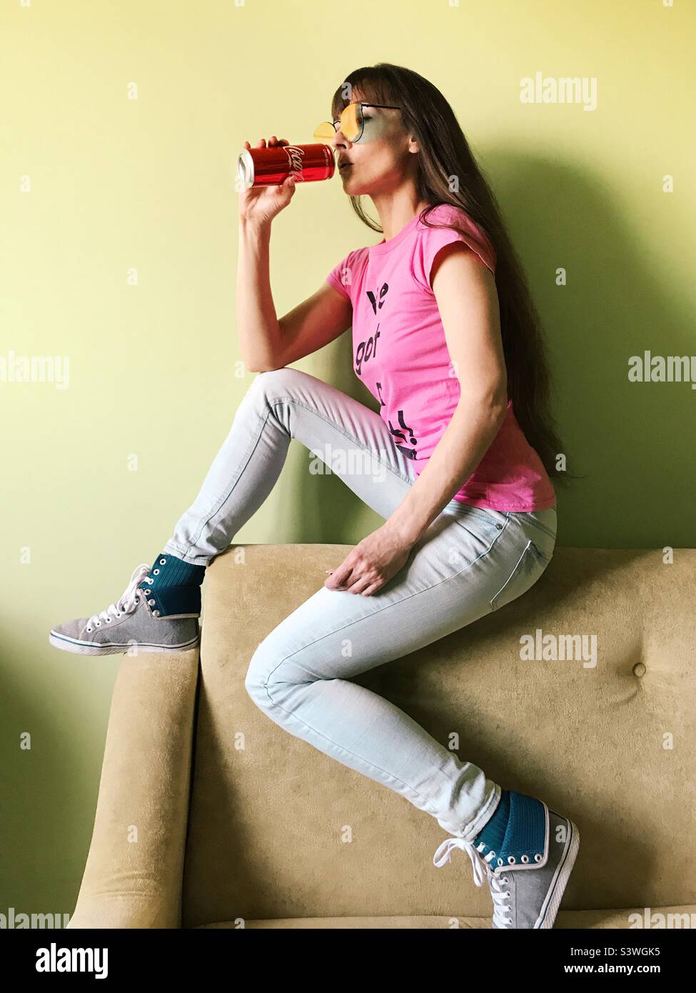 Young woman drinking coca-cola in casual clothes Stock Photo - Alamy