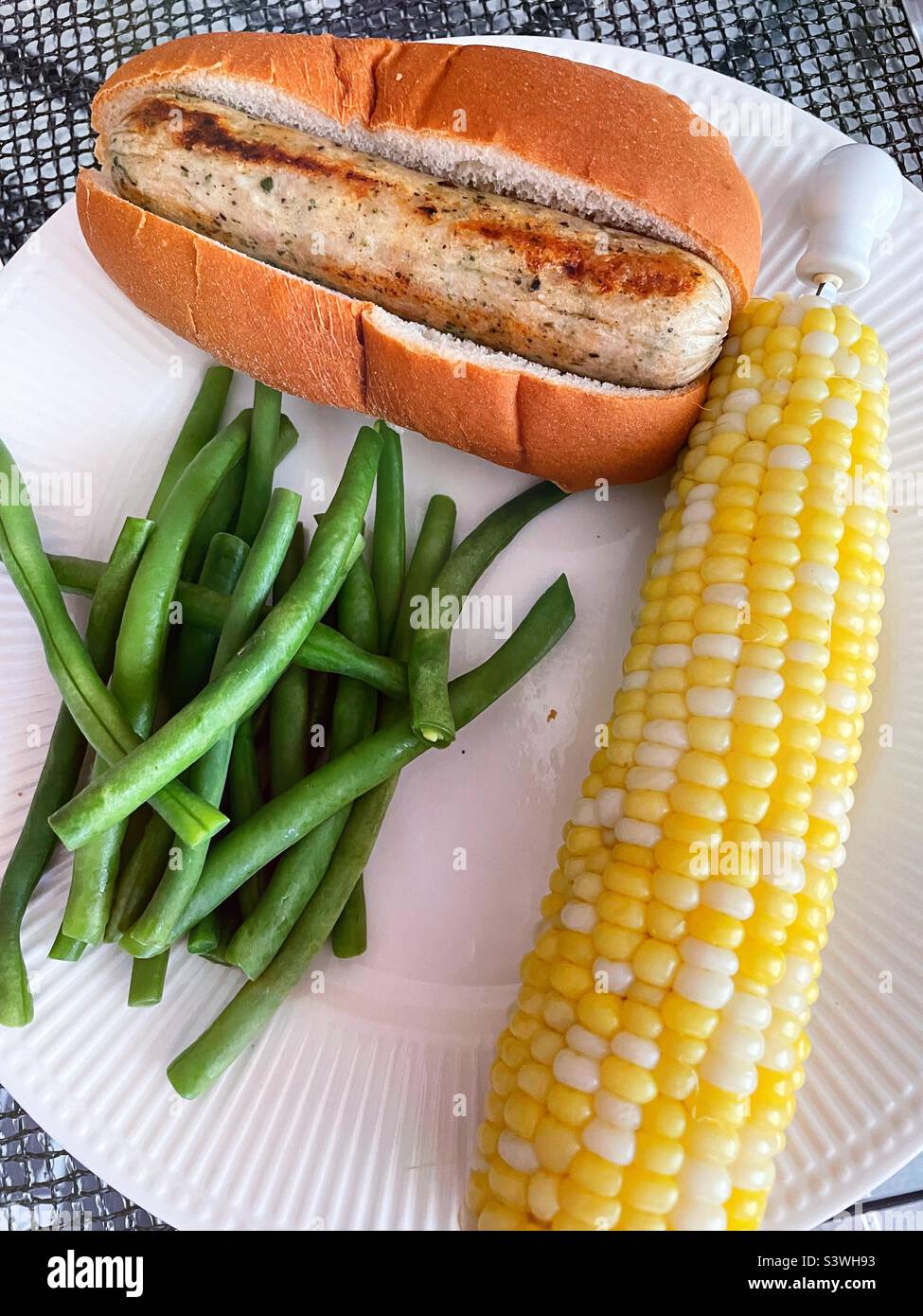 Close-up of an all American summer meal of fresh corn on the cob, green ...