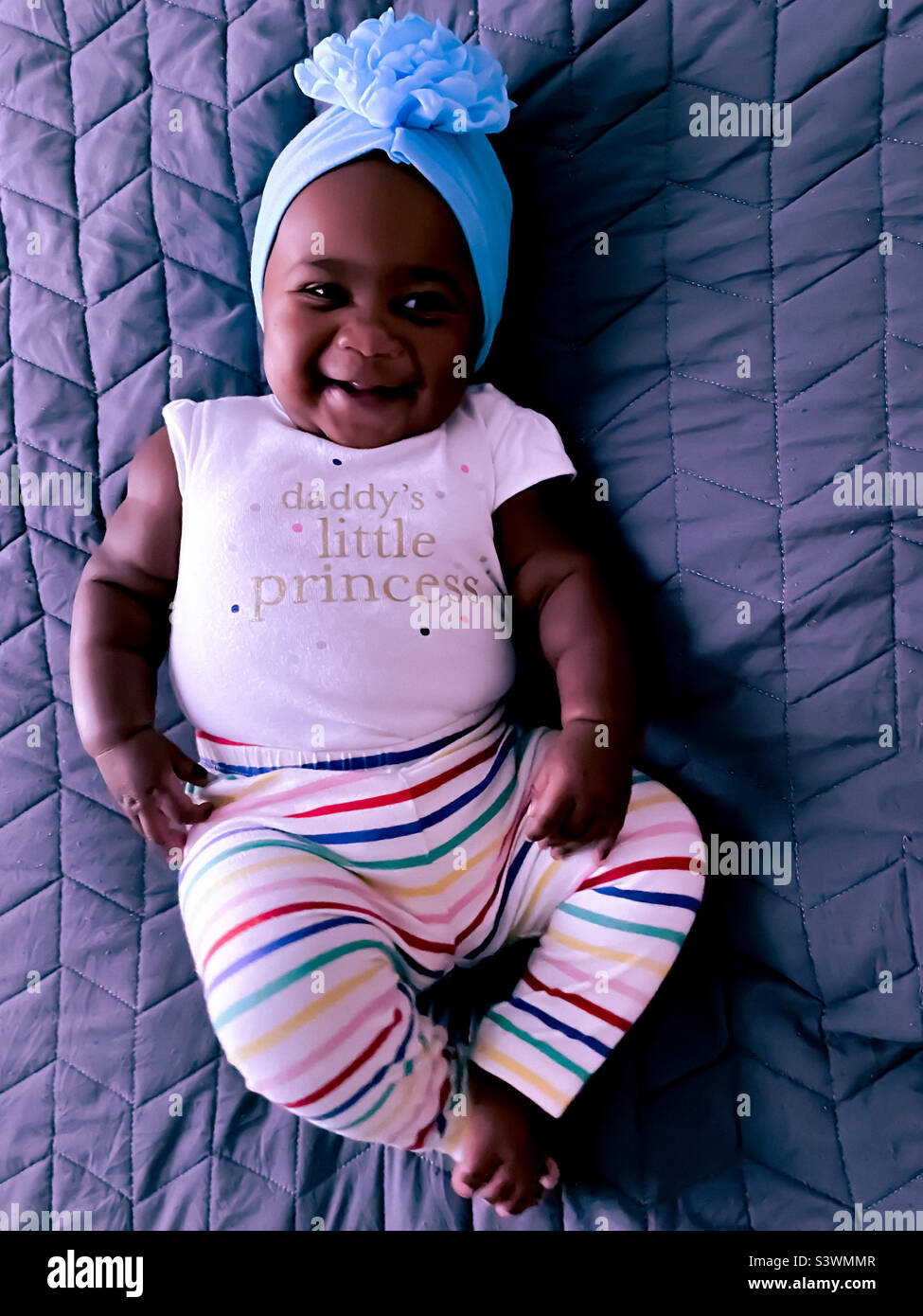 Dramatic photo of a black infant baby girl wearing bright colored ...