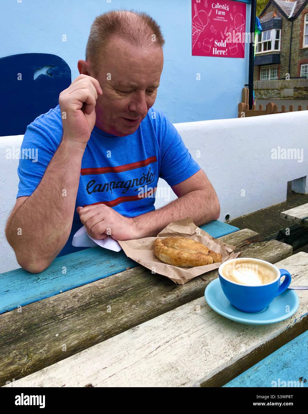 Man looking at Cornish pasty and coffee Stock Photo - Alamy
