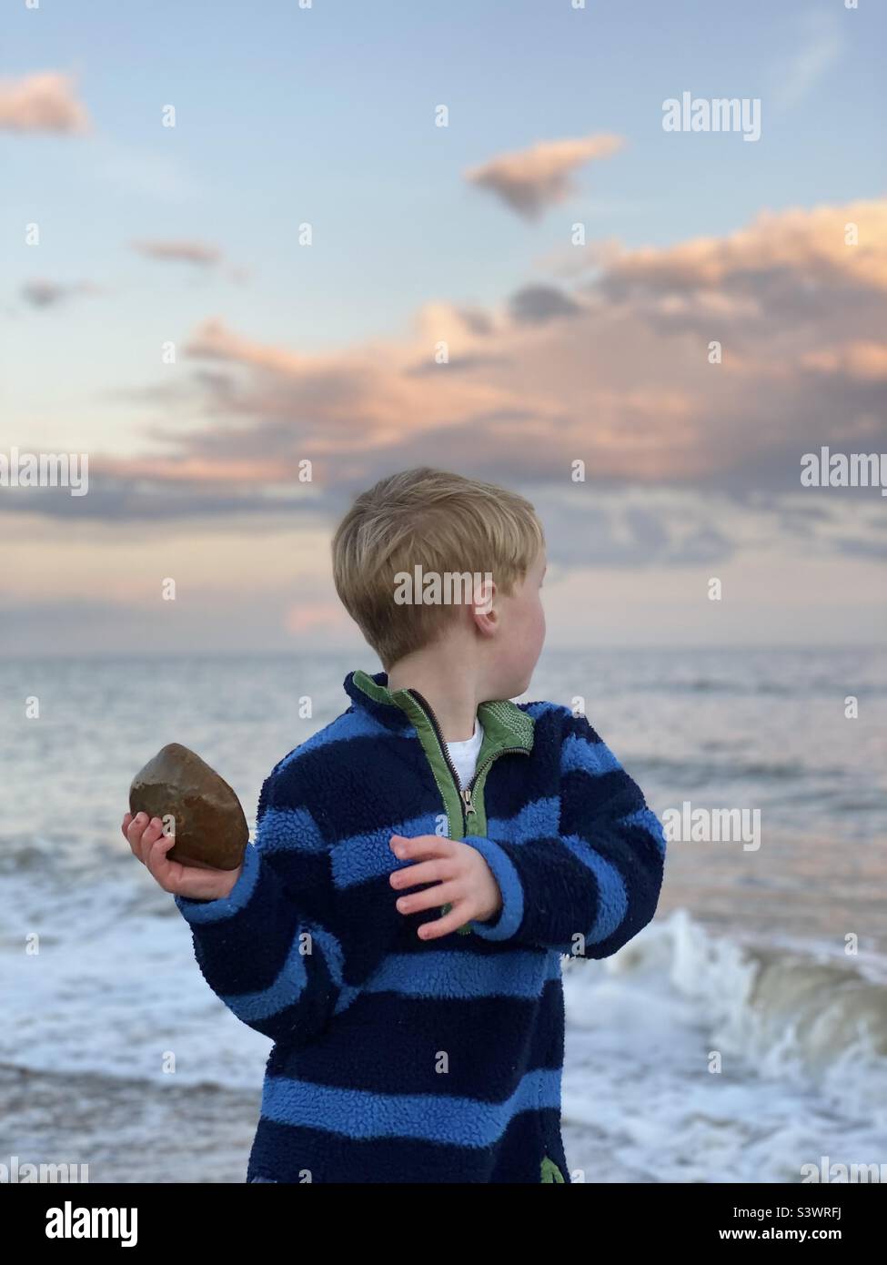Little boy throwing stones at the beach Stock Photo - Alamy