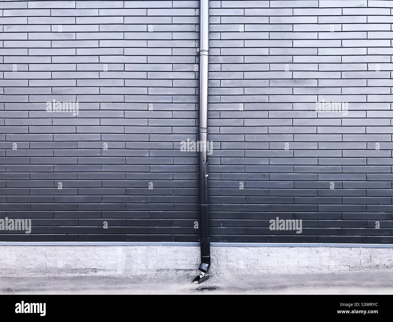Metallic drain pipe on metallic brick wall Stock Photo - Alamy